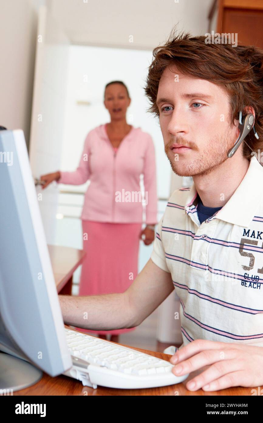 Mother calling son who is looking at computer in his room Stock Photo ...