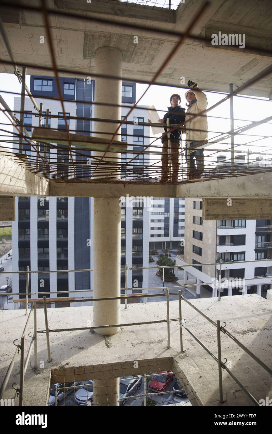 Architect and construction worker looking at blueprints, personal ...