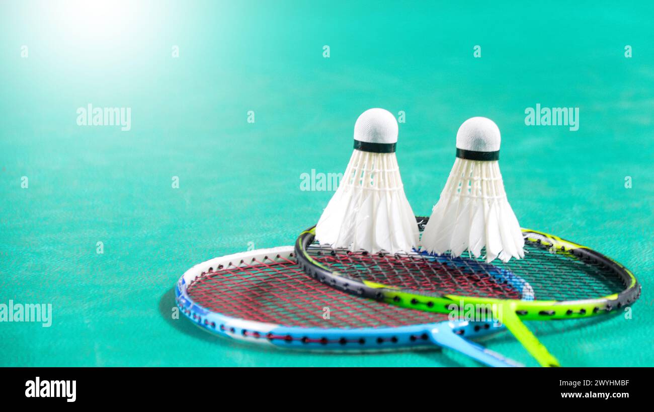 White badminton shuttlecocks and badminton rackets on green floor Stock ...