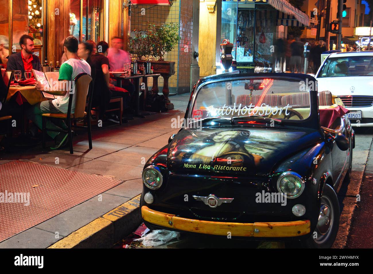 A classic Fiat is parked at an alfresco Mona Lisa, a cafe and ...