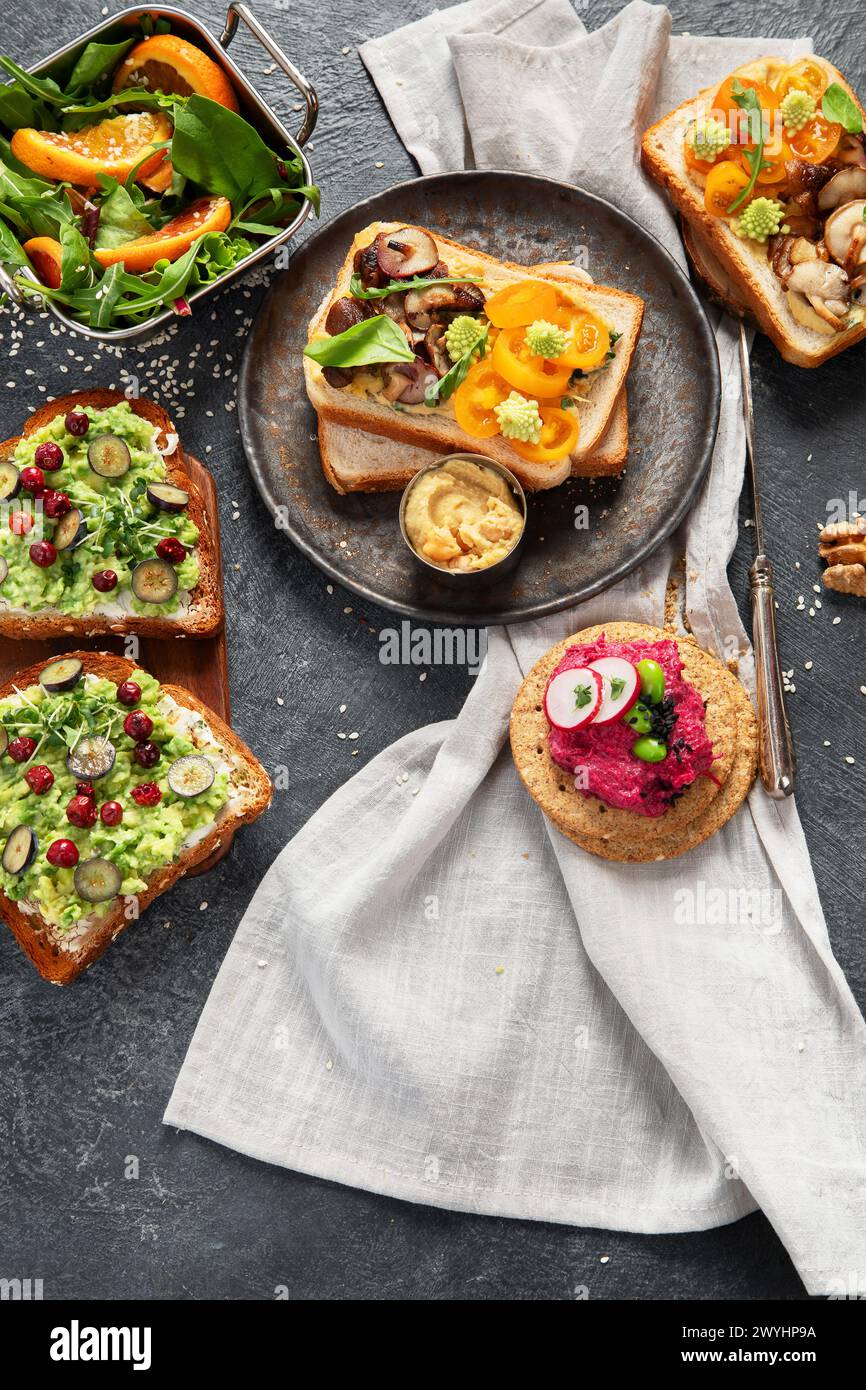 Vegan toast with avocado,mushroom and fresh salad on dark background ...