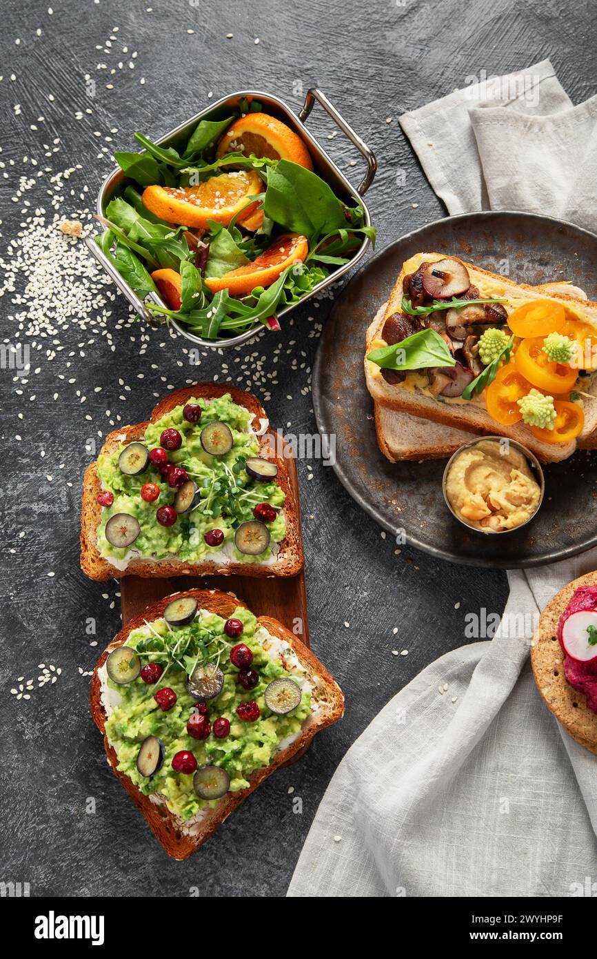 Vegan toast with avocado,mushroom and fresh salad on dark background ...