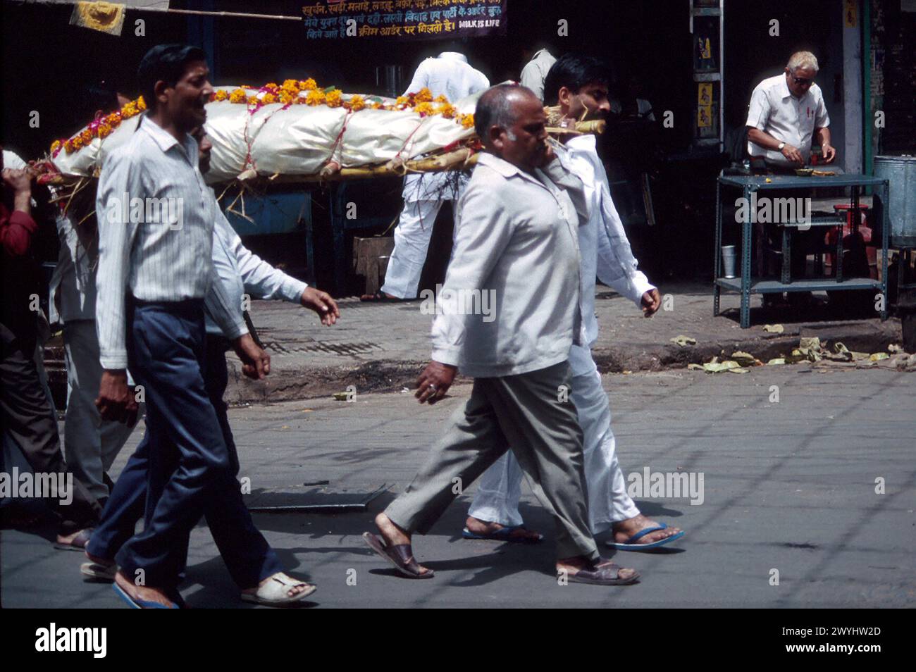 Shrouded body of a deceased person is carried on a stretcher to ...