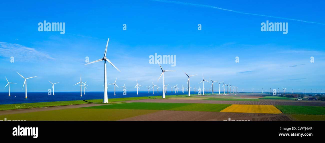 A picturesque scene of windmills gracefully spinning in a row on a lush ...