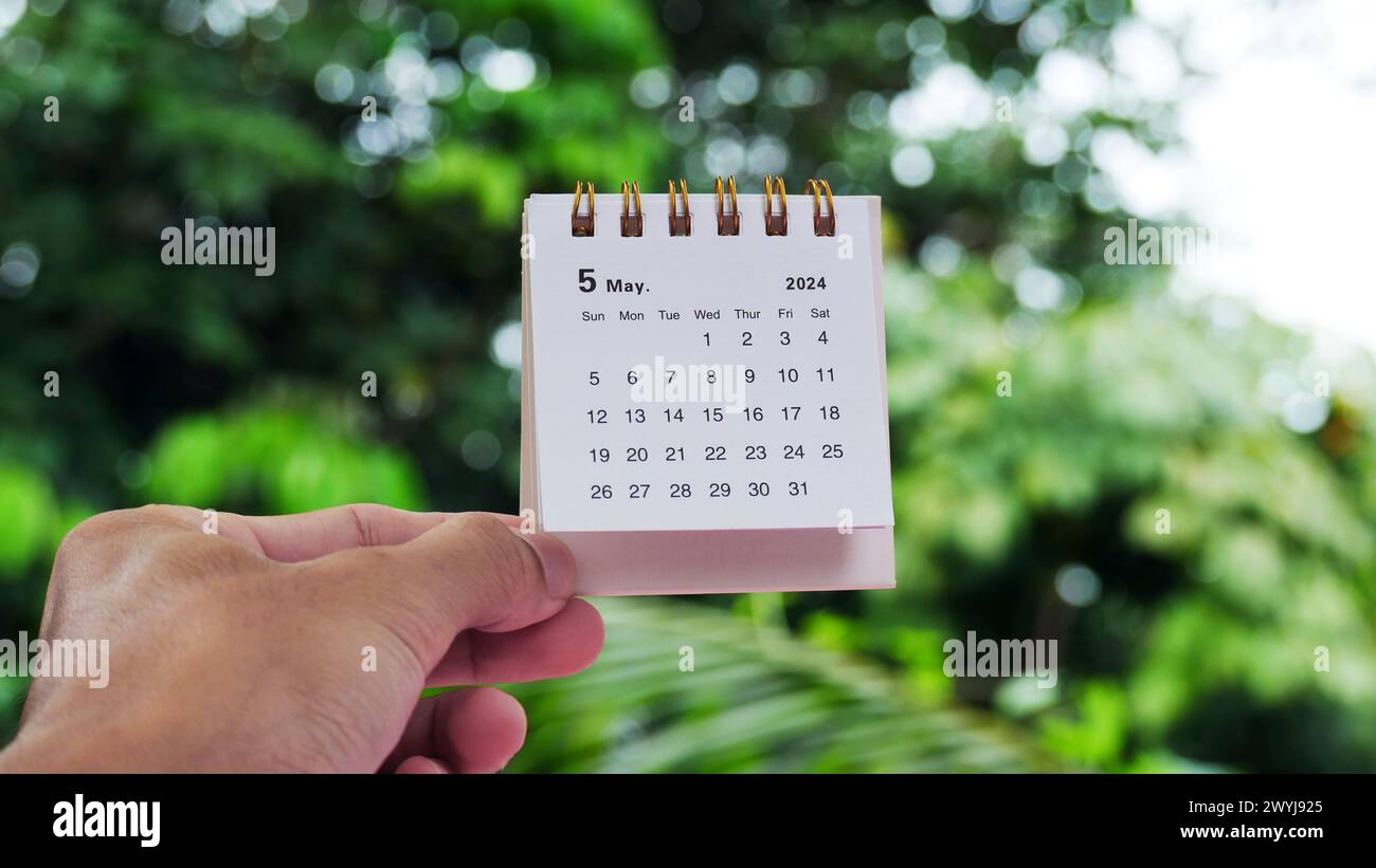 Hand flipping calendar sheet from April to May 2024 Stock Photo - Alamy