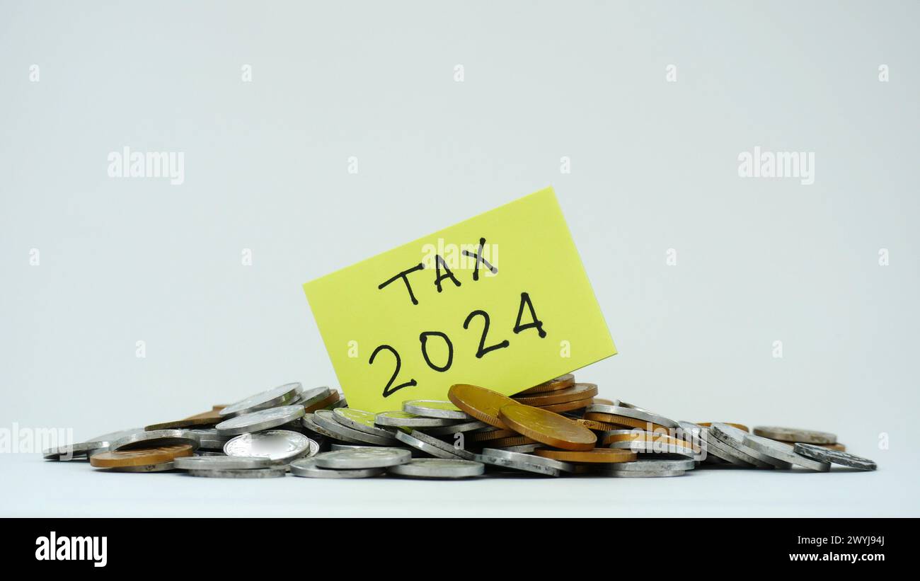 Concept of paying taxes in 2024. TAX 2024 note paper on stack of coins ...