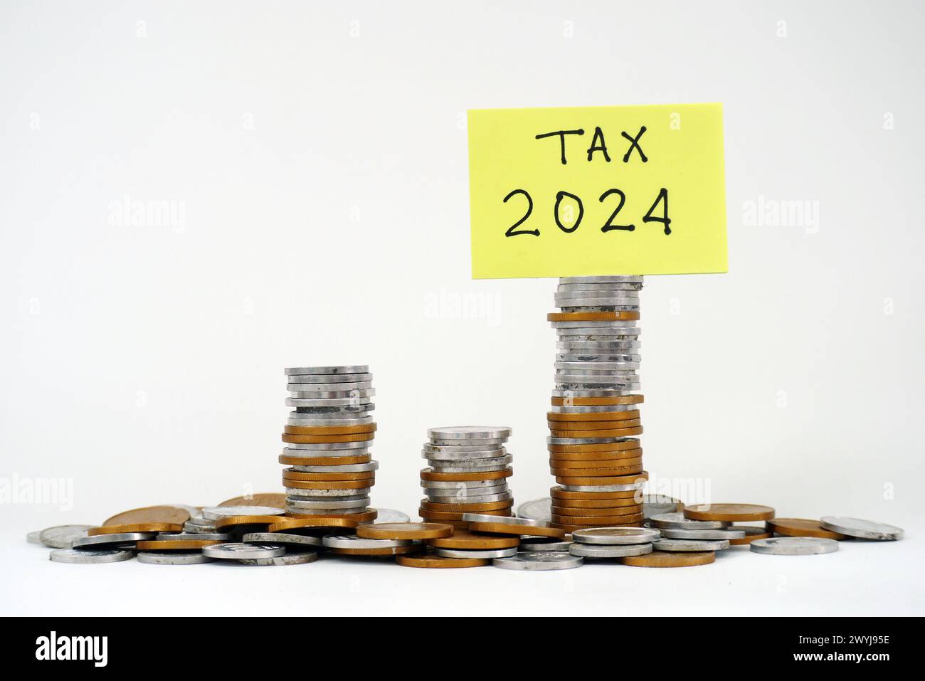 Concept of paying taxes in 2024. TAX 2024 note paper on stack of coins Stock Photo - Alamy