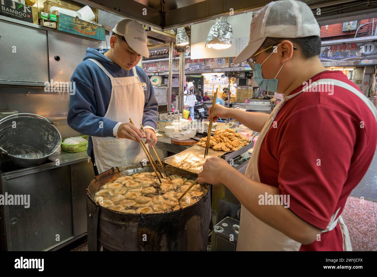 Young chefs frying snacks at a night market Stock Photo - Alamy