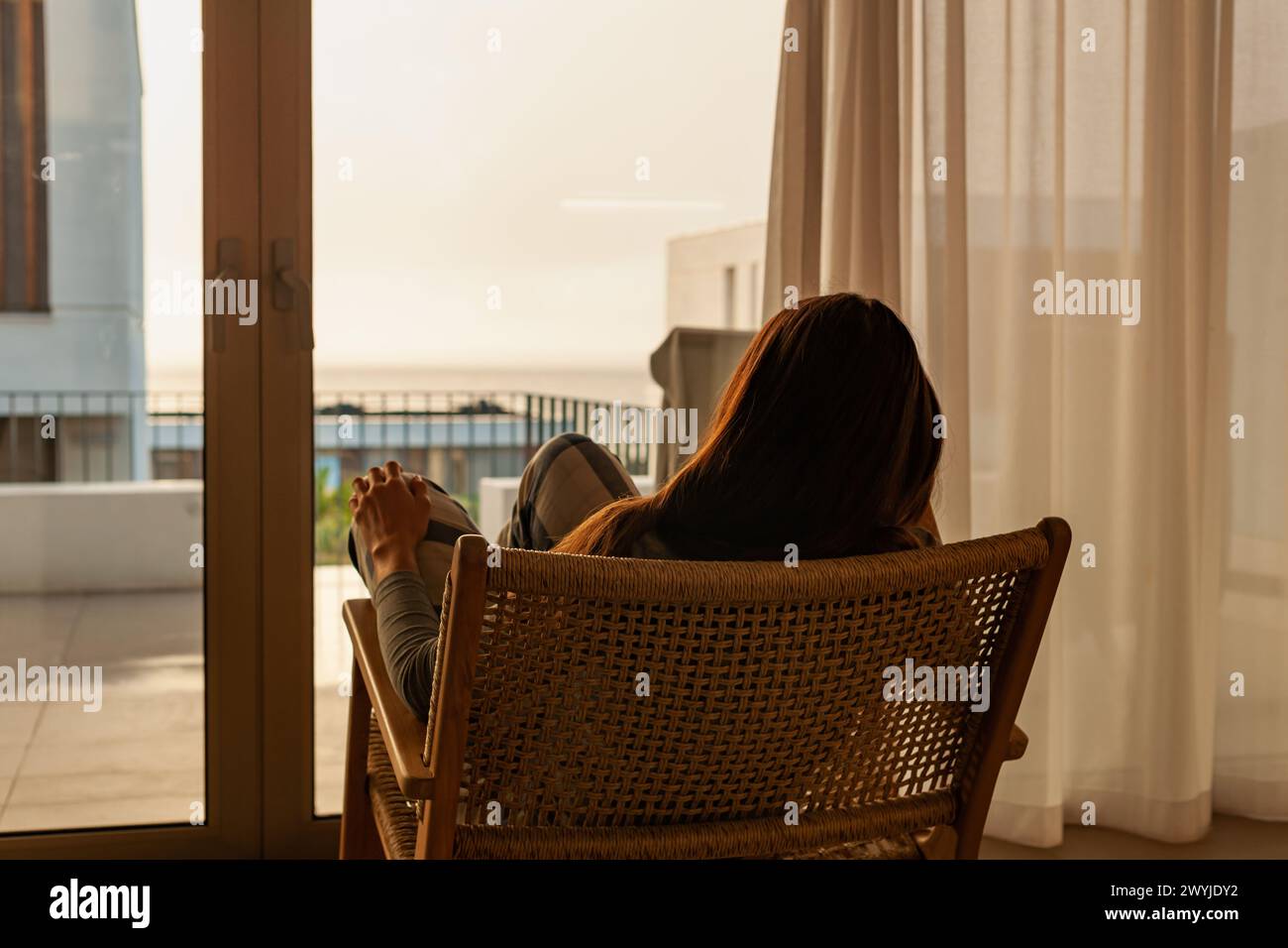 Woman sitting taking a relaxing moment in an armchair Stock Photo - Alamy