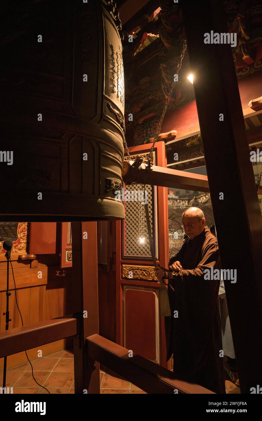 A monk in traditional attire looking at his watch waiting for the time ...