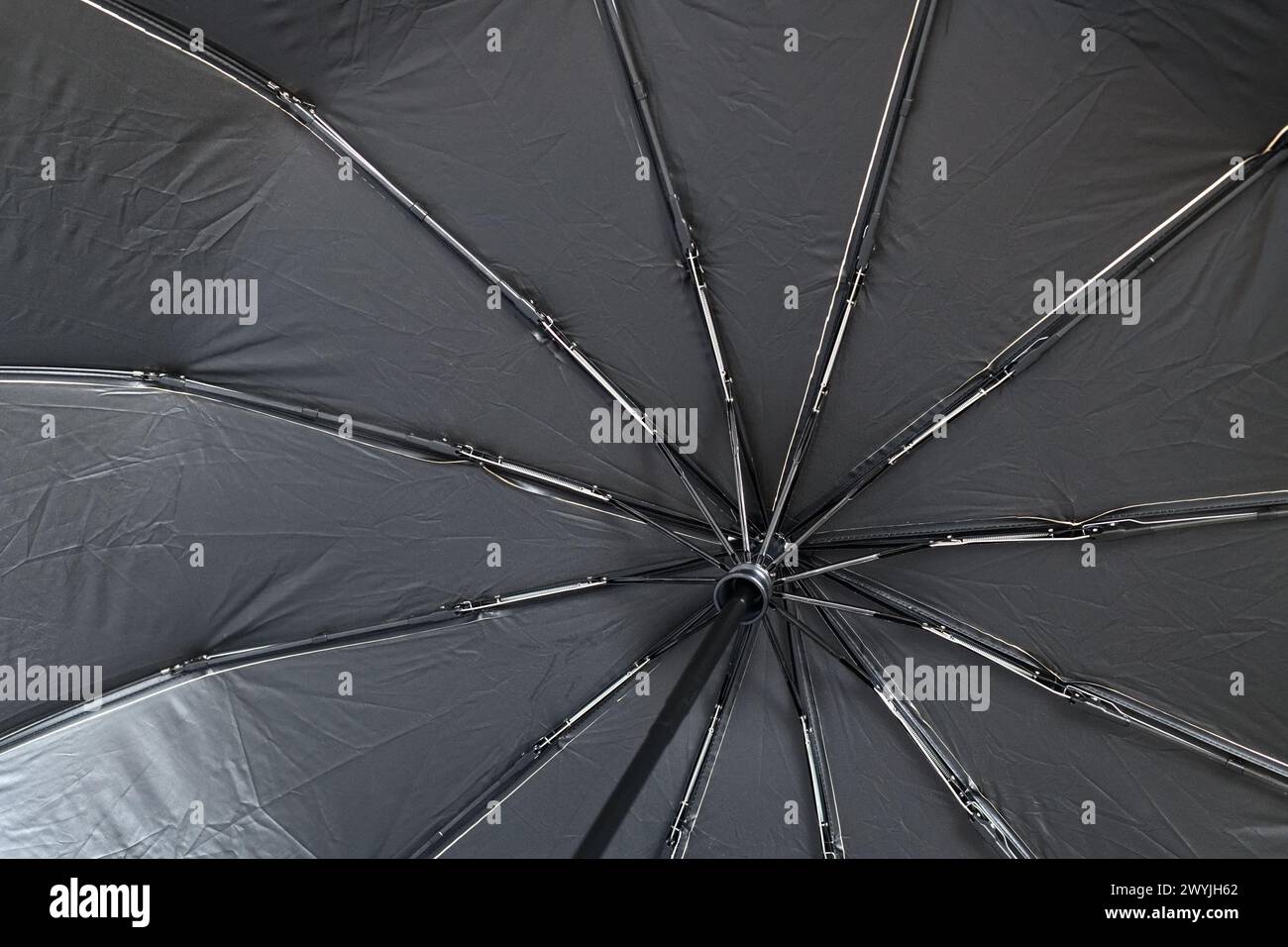 The inside of black umbrella with spokes Stock Photo - Alamy
