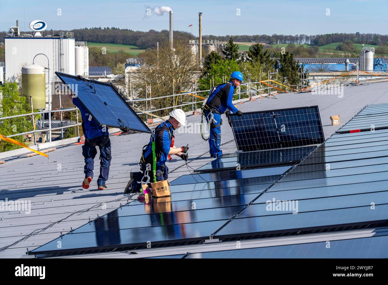 Montage von Solarmodulen auf dem Dach eines Gewerbebetriebs, über 400 Photovoltaik Module werden ...