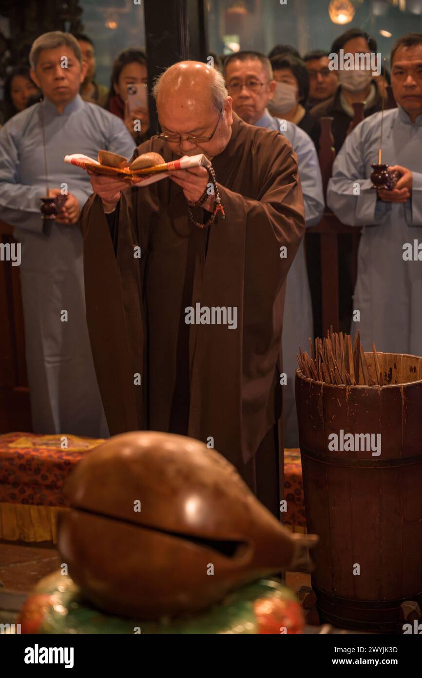 A monk deeply engrossed in prayer using prayer beads during a solemn ...