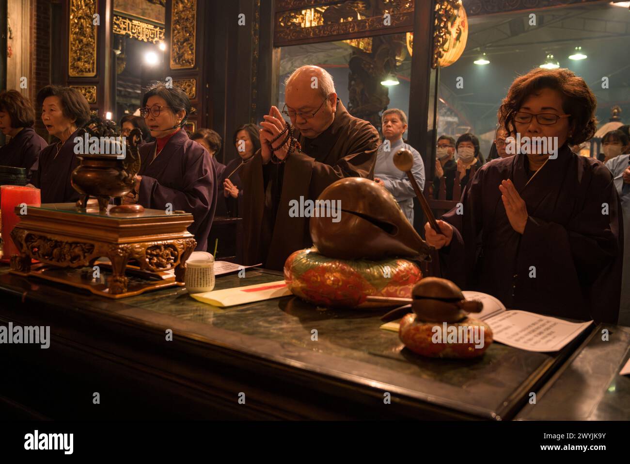 A monk deeply engrossed in prayer using prayer beads during a solemn ...