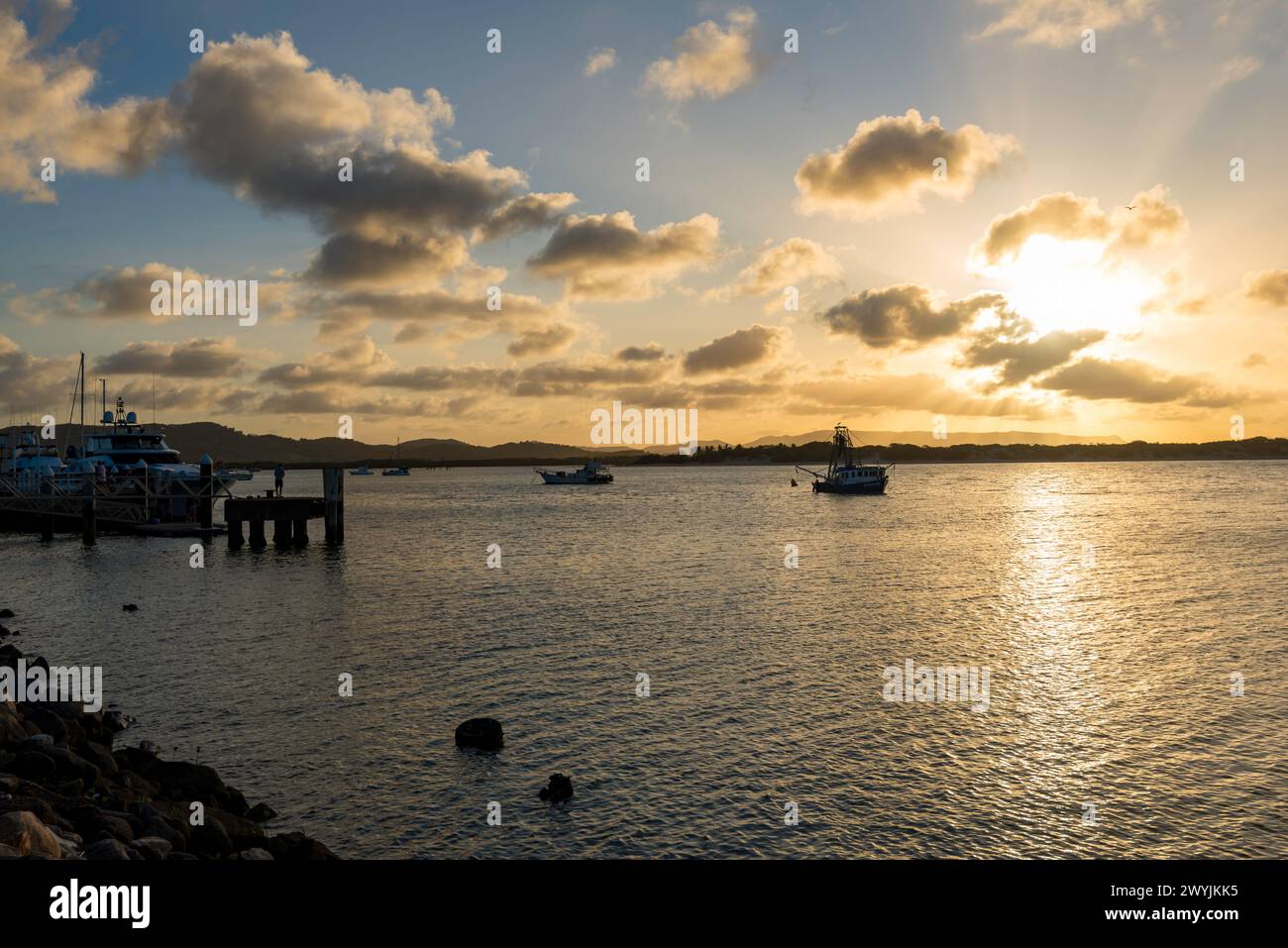 People fishing at the waterfront at sunset in Cooktown in Far North ...