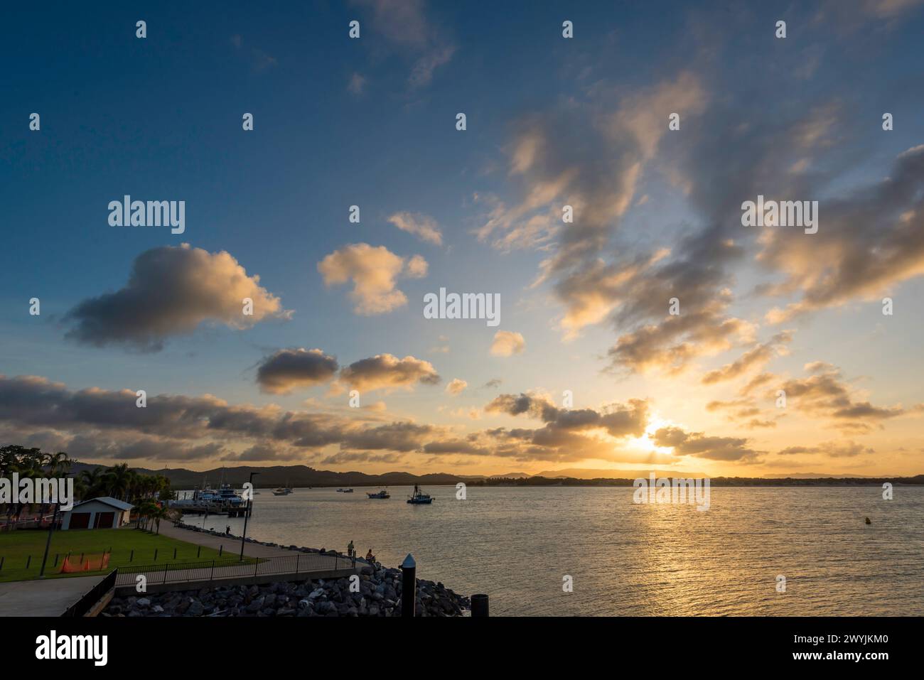 People fishing at the waterfront at sunset in Cooktown in Far North ...