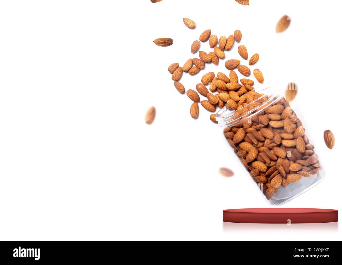 Almonds falling from glass jar isolated on white background with copy ...
