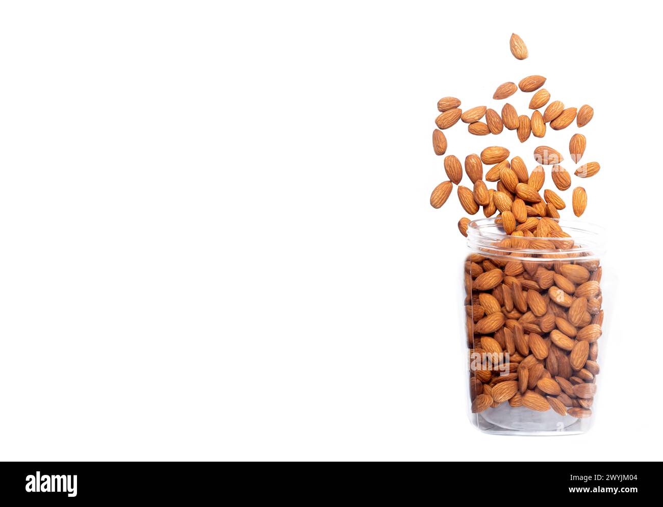 Almonds falling in glass jar on white background with copy space Stock ...