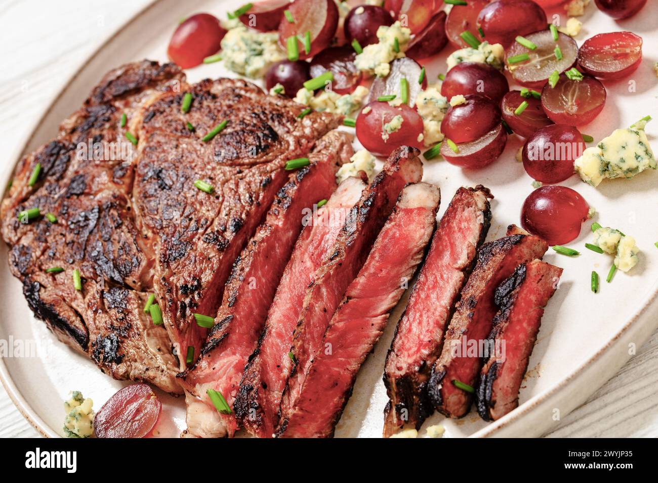 pan fried beef steak served with salad of red grape, crumbled blue mold ...