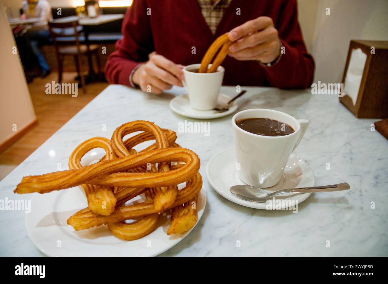 Man having chocolate with churros. Close view Stock Photo - Alamy