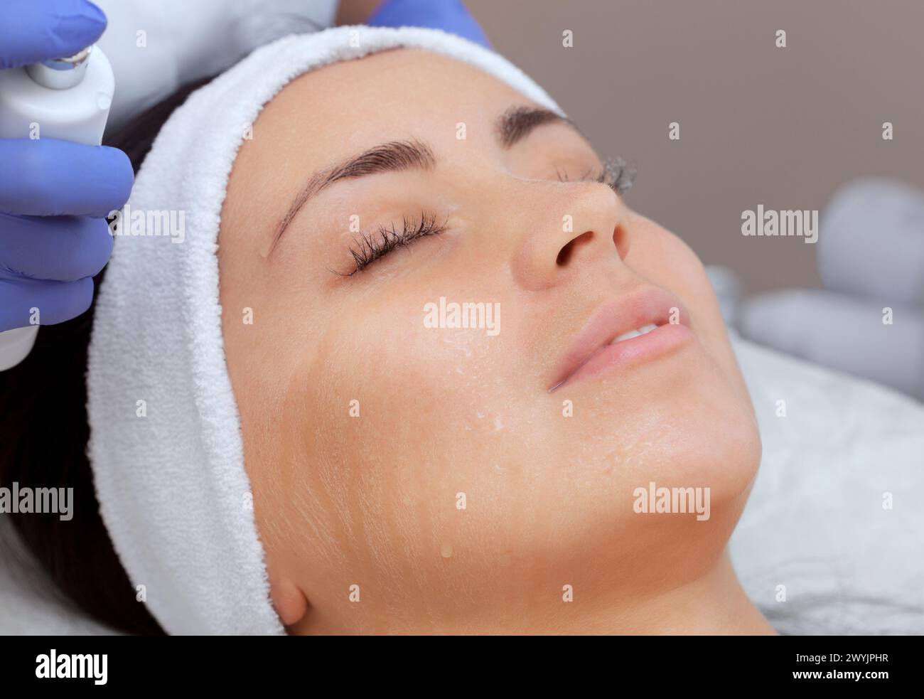 The procedure of steaming the skin of the face of a young woman before ...