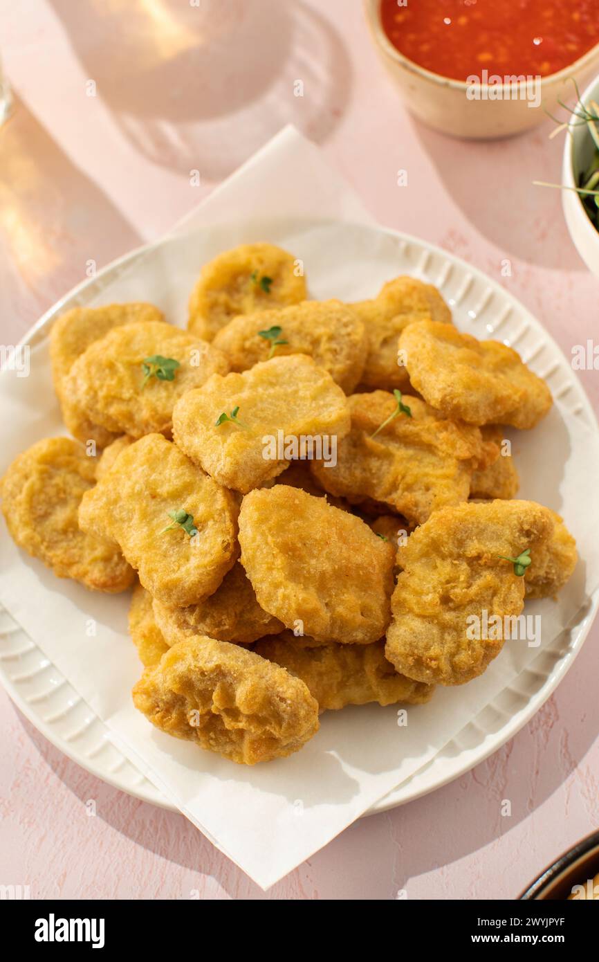 Delicious golden chicken nuggets on a plate on the table. Fast food ...