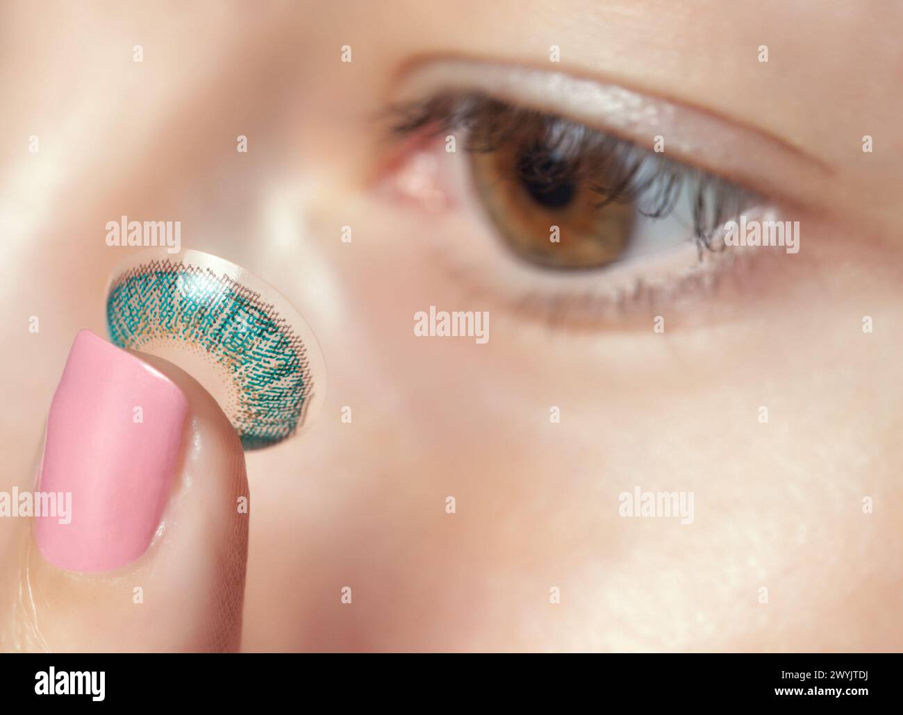 One woman holds a blue contact lens on her finger. Eye care and the ...