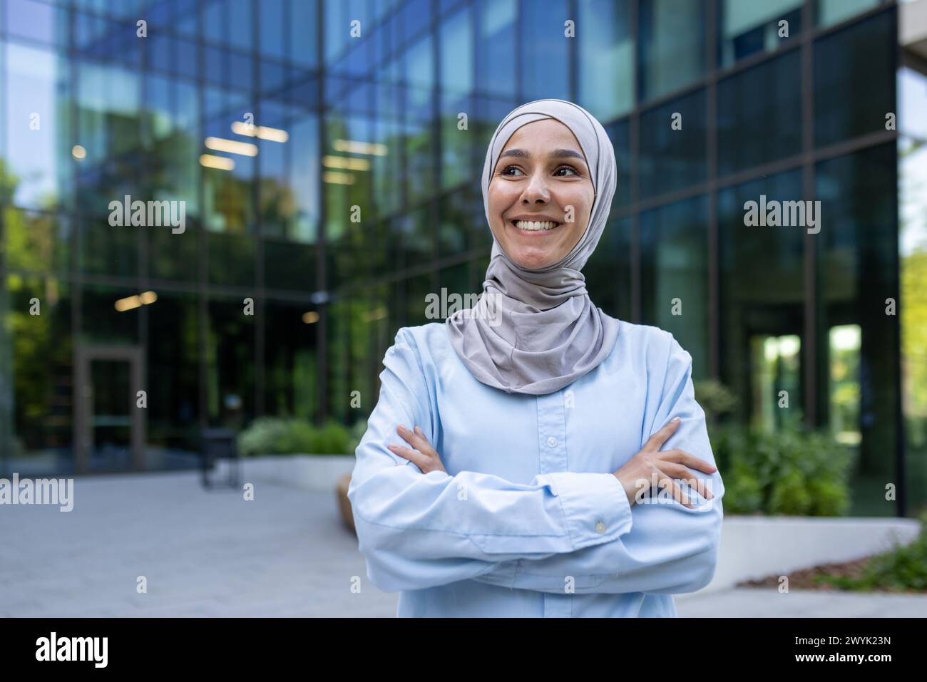 Professional Muslim woman in a hijab stands confidently outside an ...
