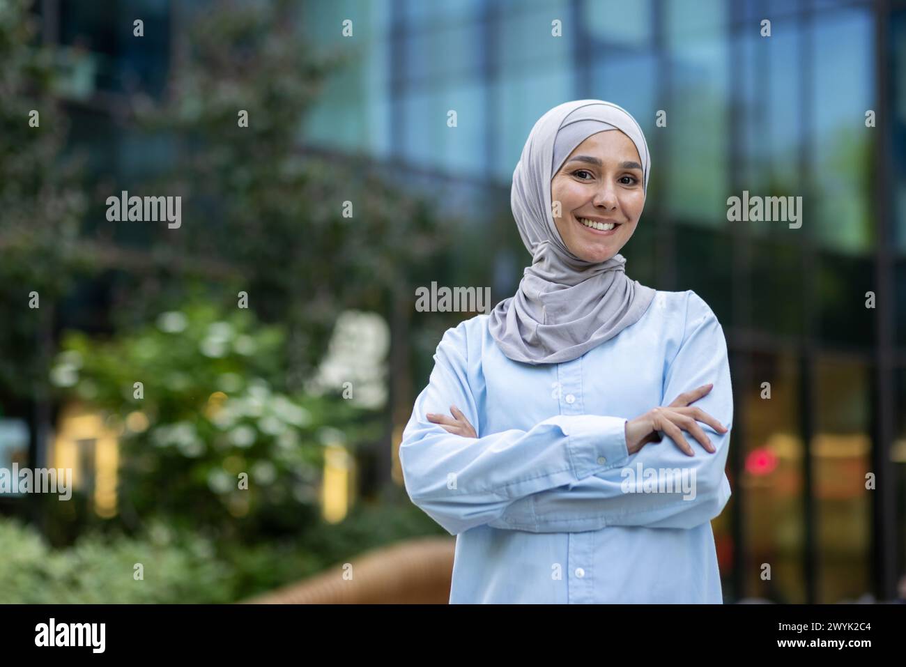 Portrait of a cheerful Muslim woman with hijab, confidently standing ...