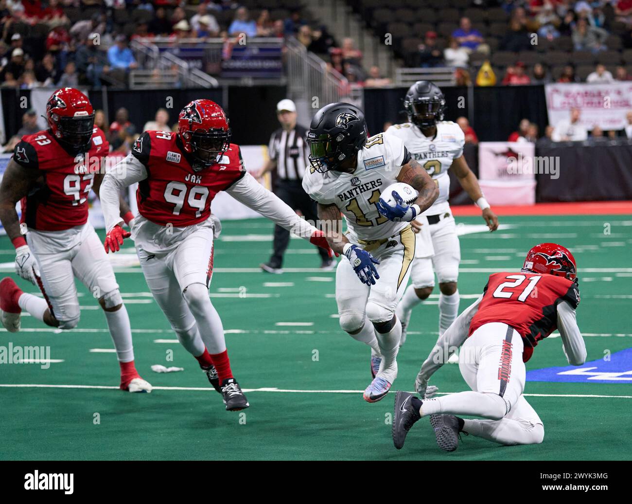 RB Shane Simpson (#11) runs through tacklers: DL Marcus Bragg (#99) and ...