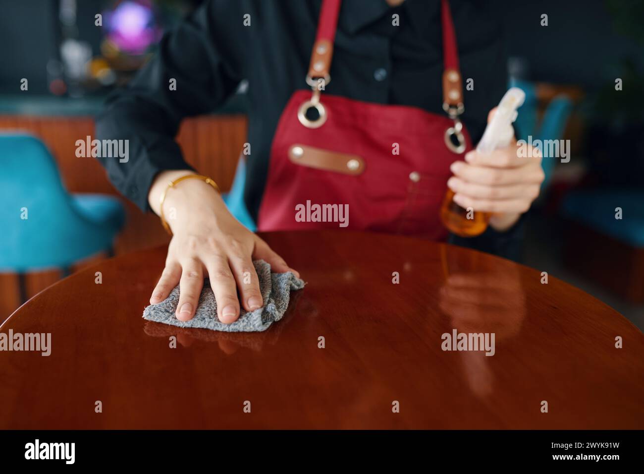 Cafe waiter polishing wooden tables with spray Stock Photo - Alamy