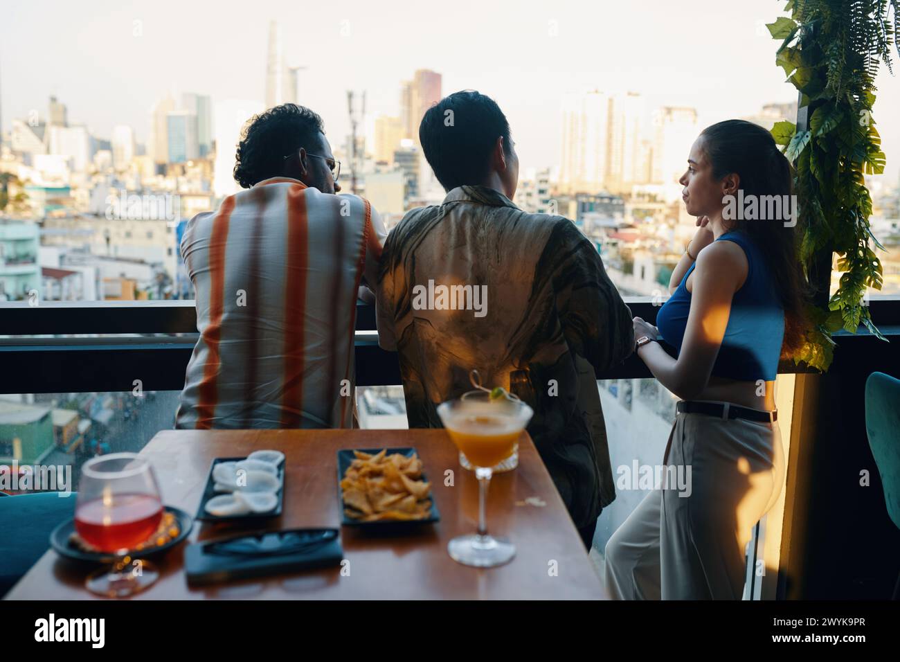 Group of colleagues spending time in rooftop bar after work Stock Photo ...