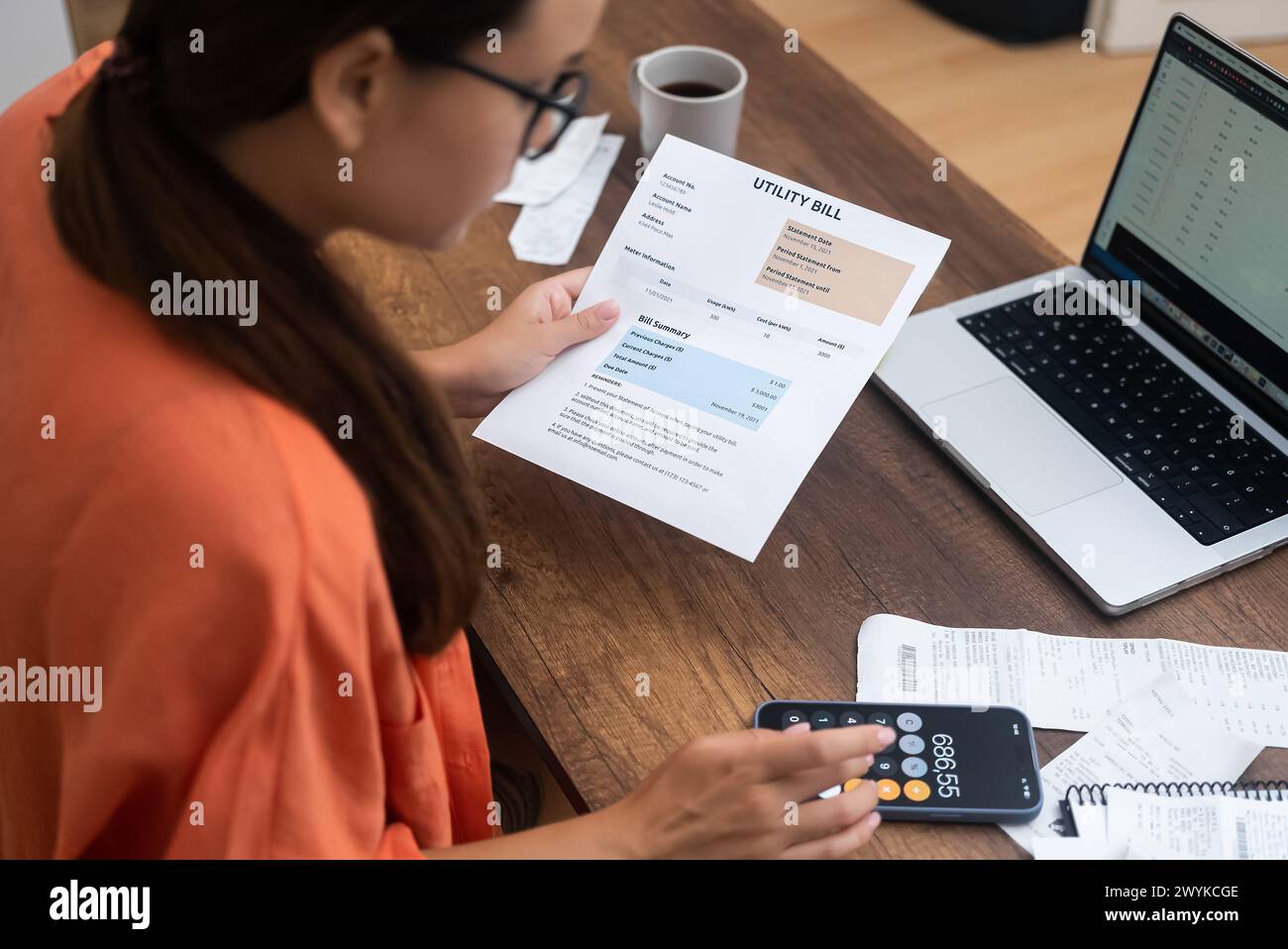 financial responsibility: woman assesses bank statements and utility ...