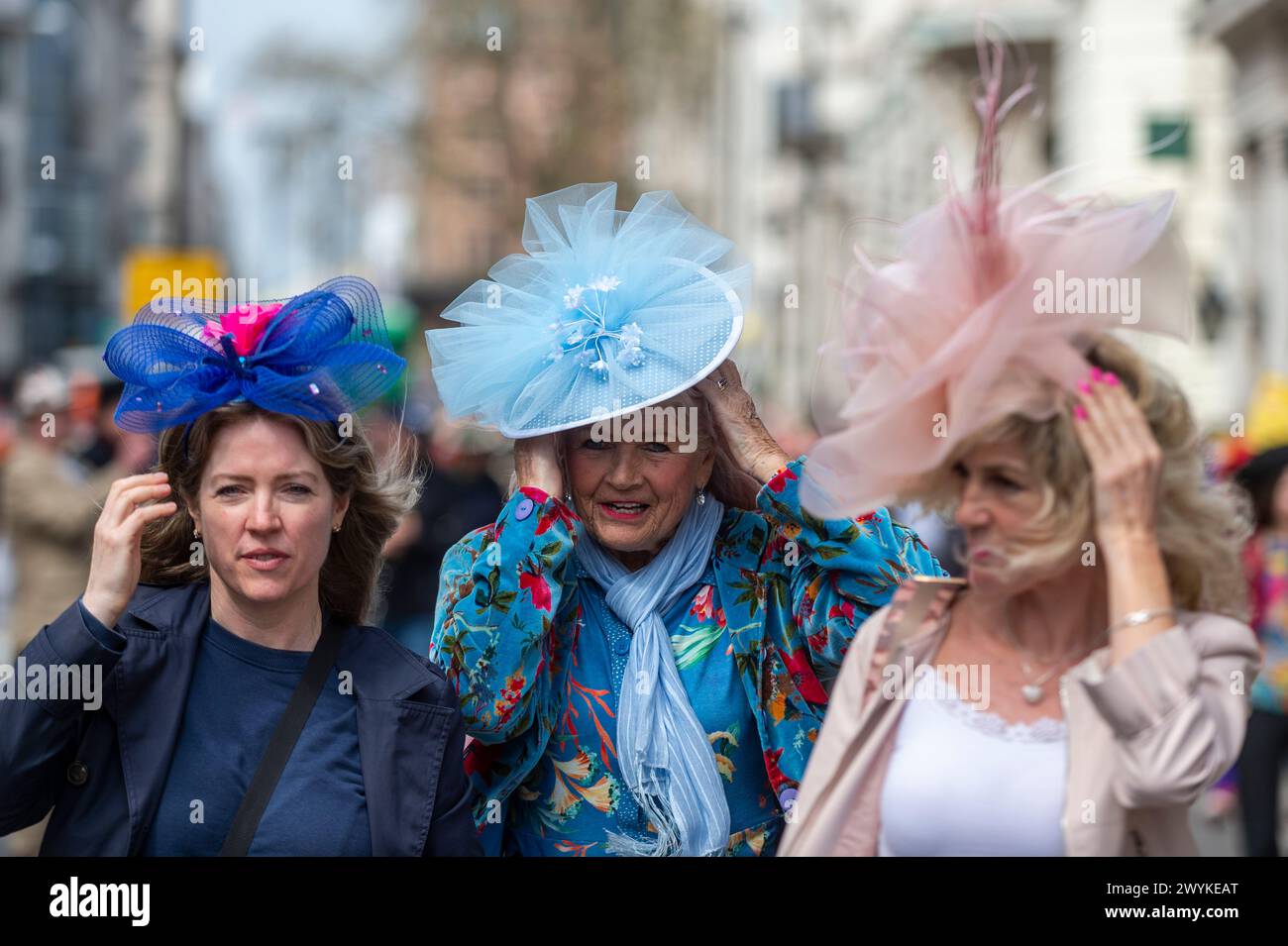 London, UK. 7 April 2024. Hat wearing enthusiasts struggle in the wind ...