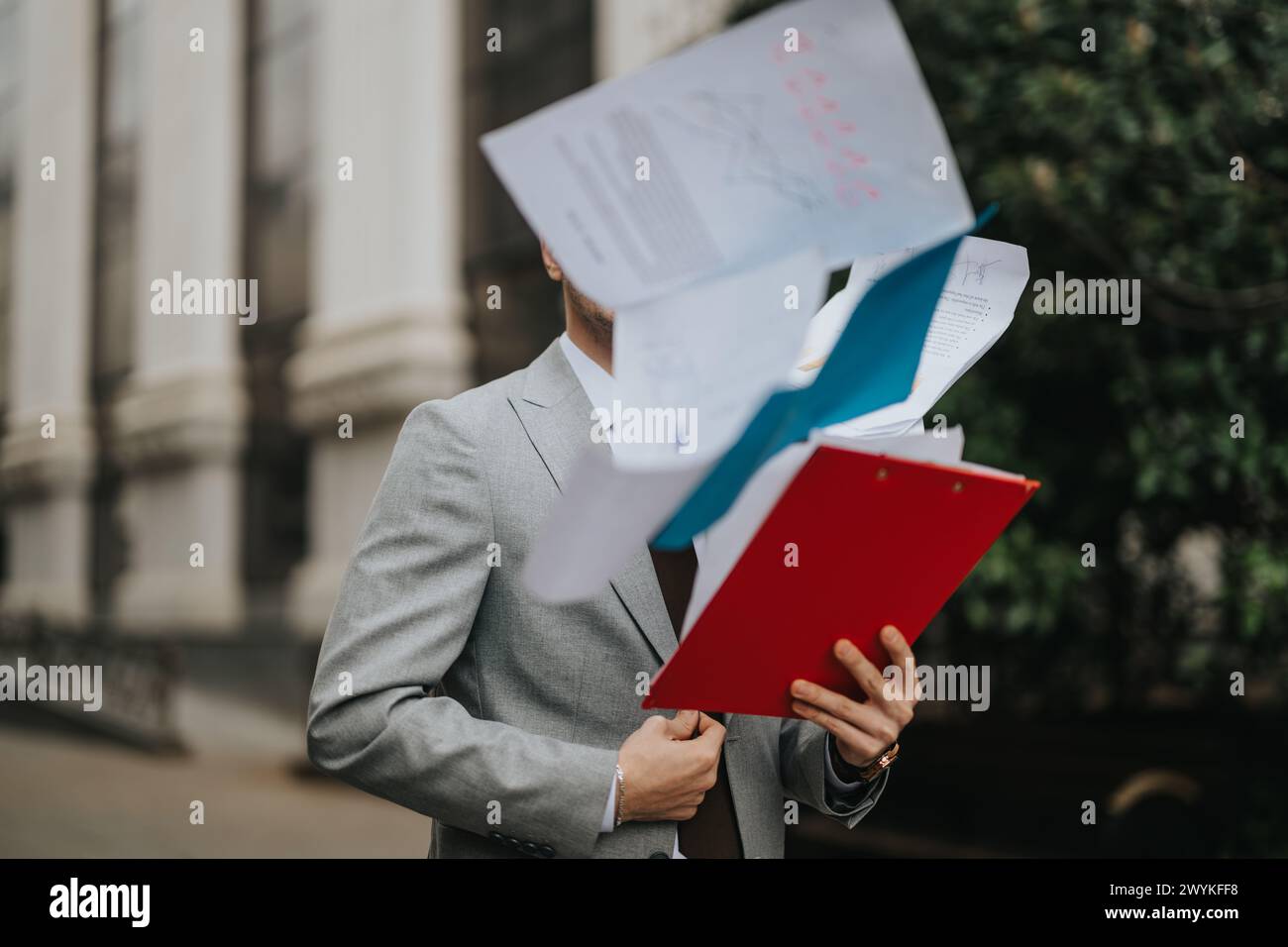 Overwhelmed business person with scattered paperwork outside office ...