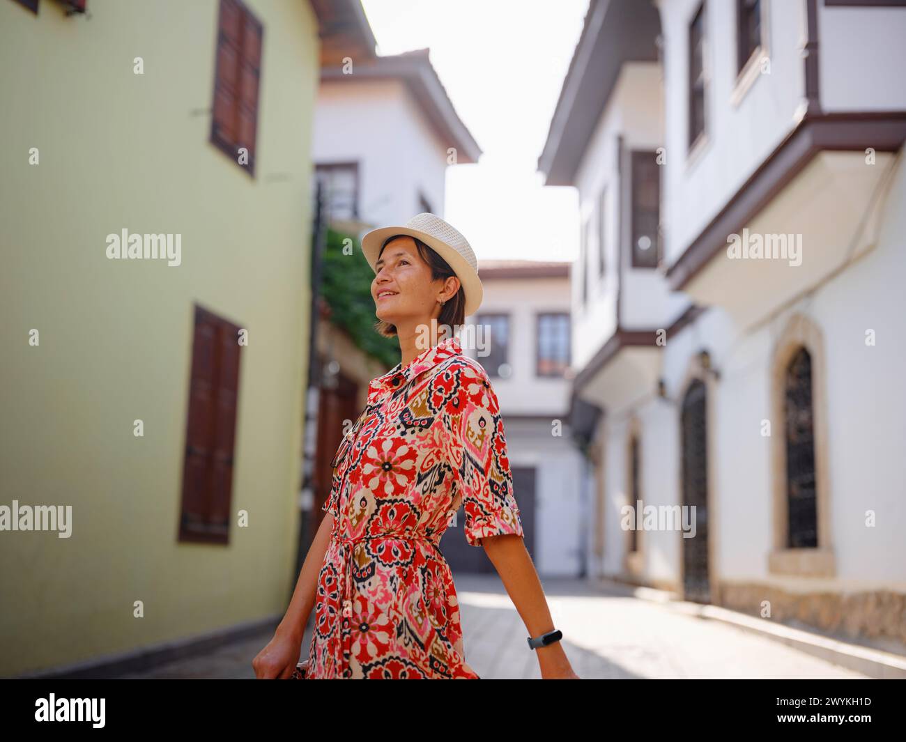 female summer travel to Antalya, Turkey. young asian woman in red dress walk through old town ...