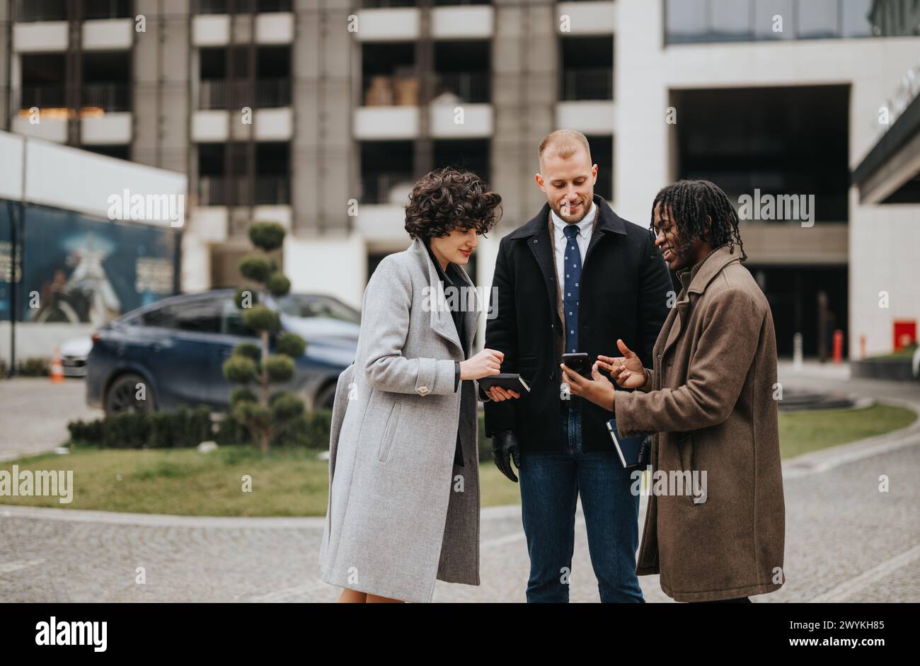 Three young, diverse business professionals engage in a collaborative ...