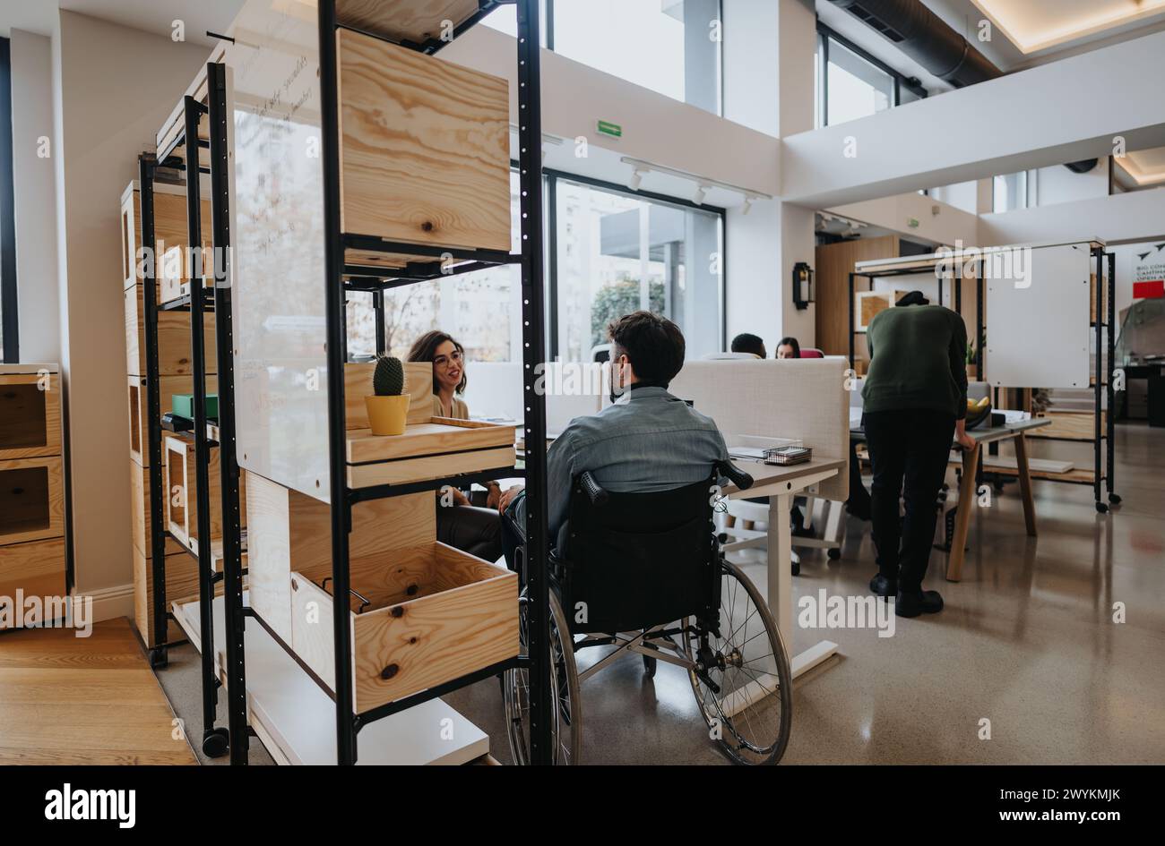 Diverse office setting featuring a wheelchair user working with ...