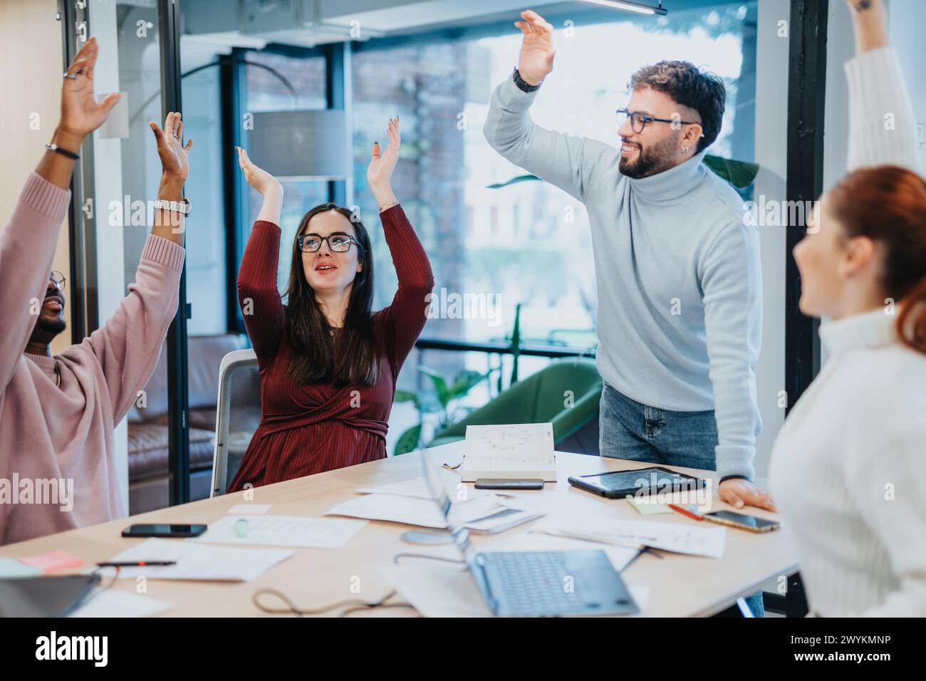 Colleagues celebrating a successful project in an office. Multiracial ...