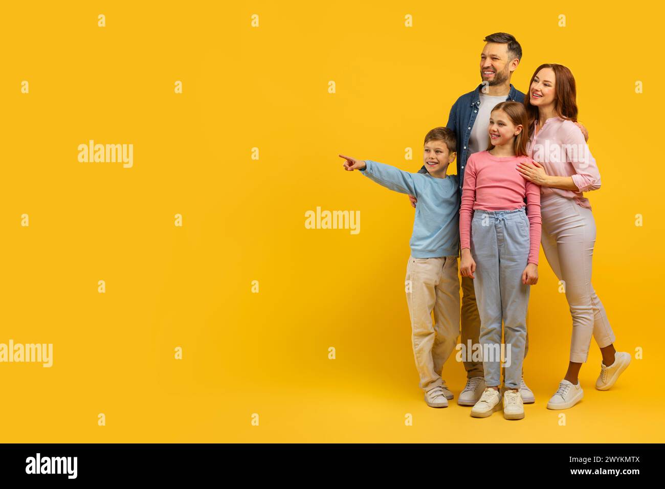 Family with two kids pointing and smiling Stock Photo - Alamy