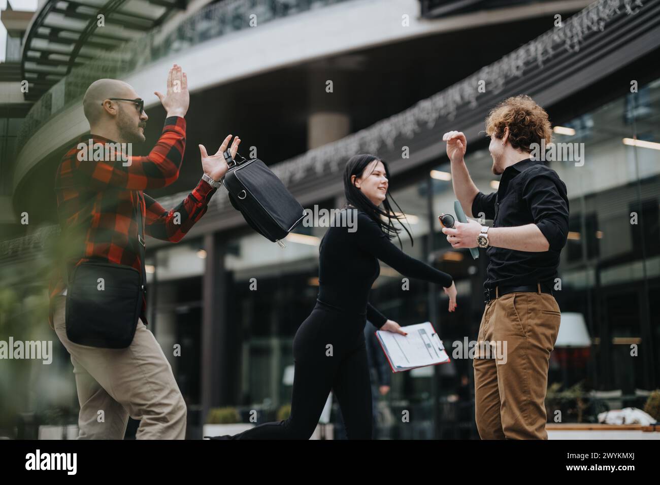 Business partners celebrating success with a high five outside an ...