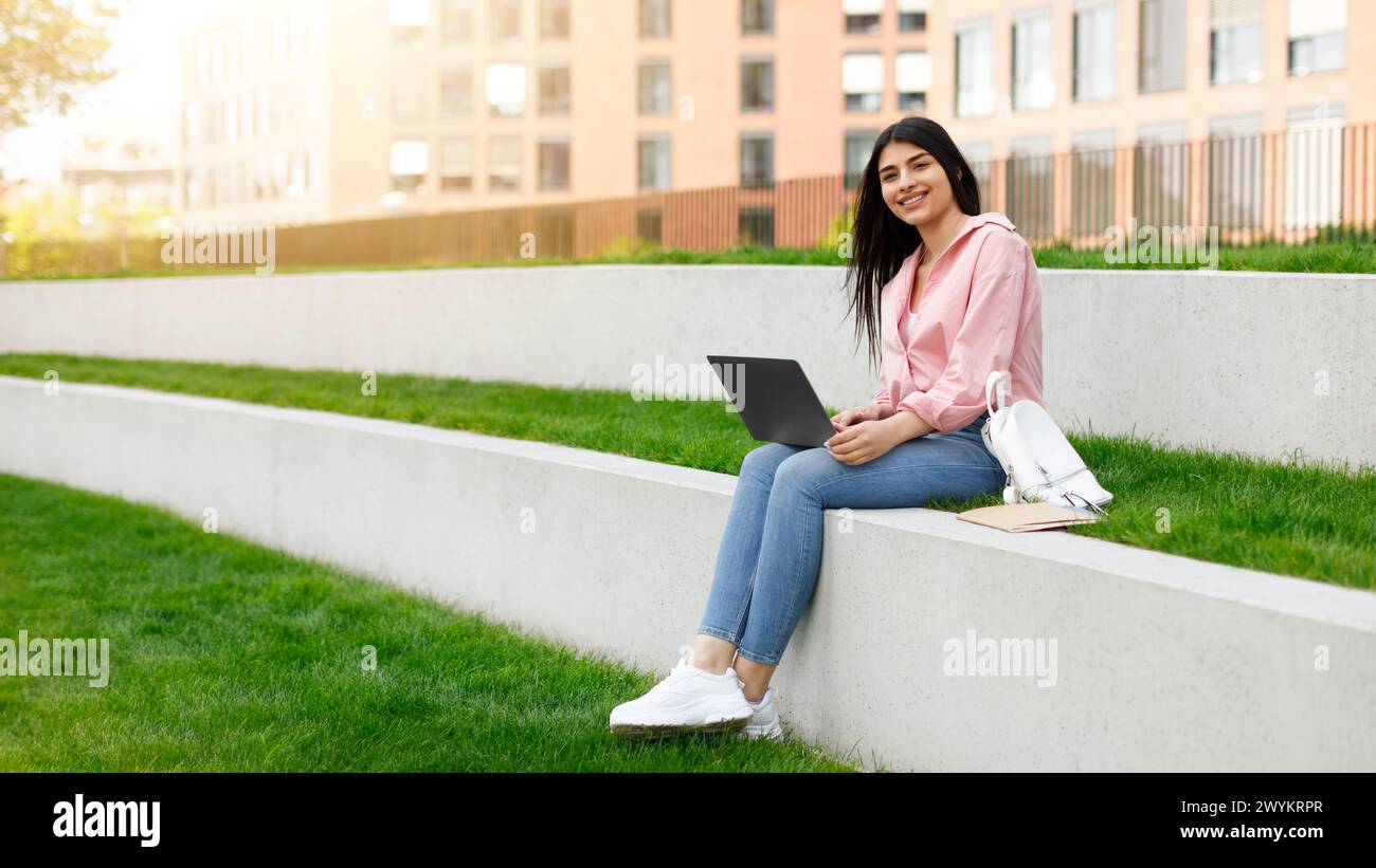 Relaxed student with laptop and notebook outside Stock Photo - Alamy