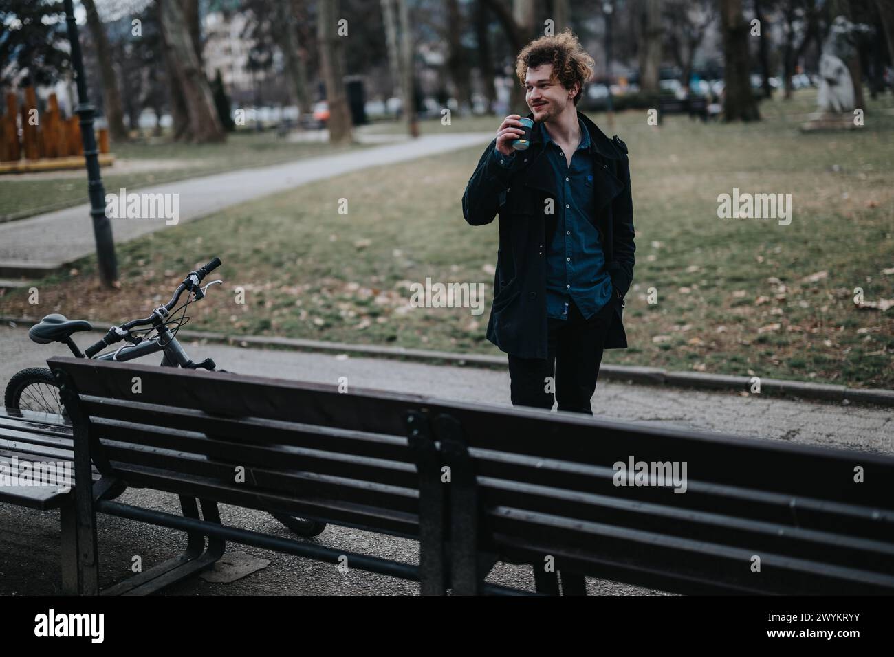 Business professional enjoying a coffee break in the park with a ...