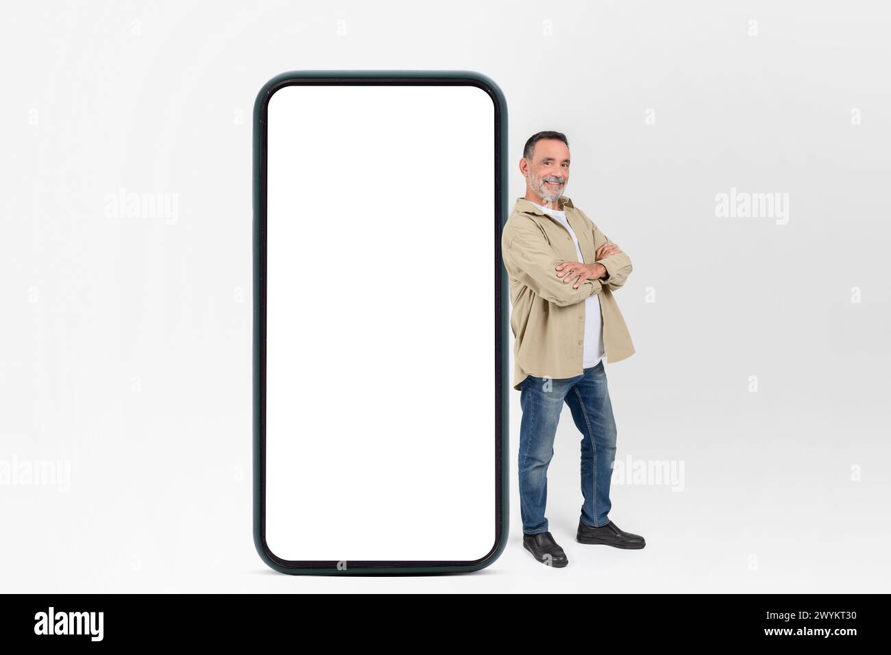 Smiling man standing with giant smartphone, mockup Stock Photo - Alamy