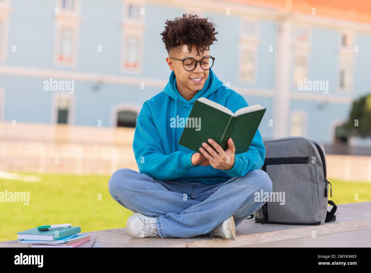 Student reading a book outdoors, studying at park Stock Photo - Alamy
