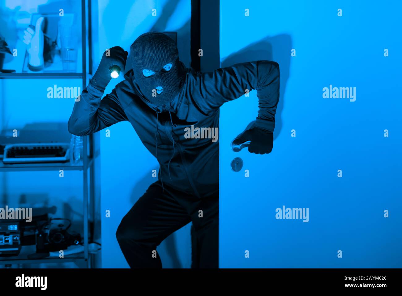 Burglar with flashlight during a night heist Stock Photo - Alamy