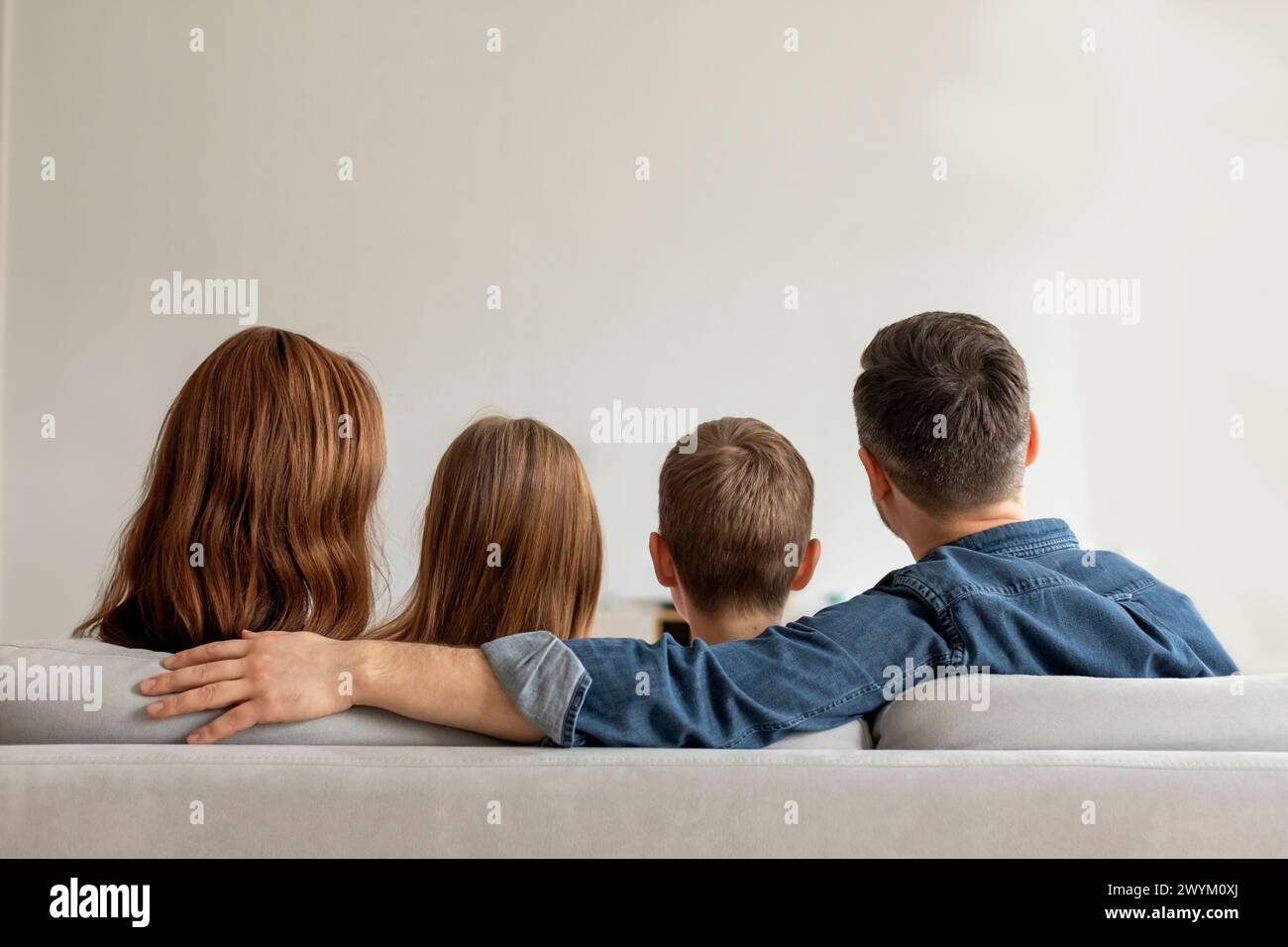 Family sitting together on sofa hi-res stock photography and images - Alamy