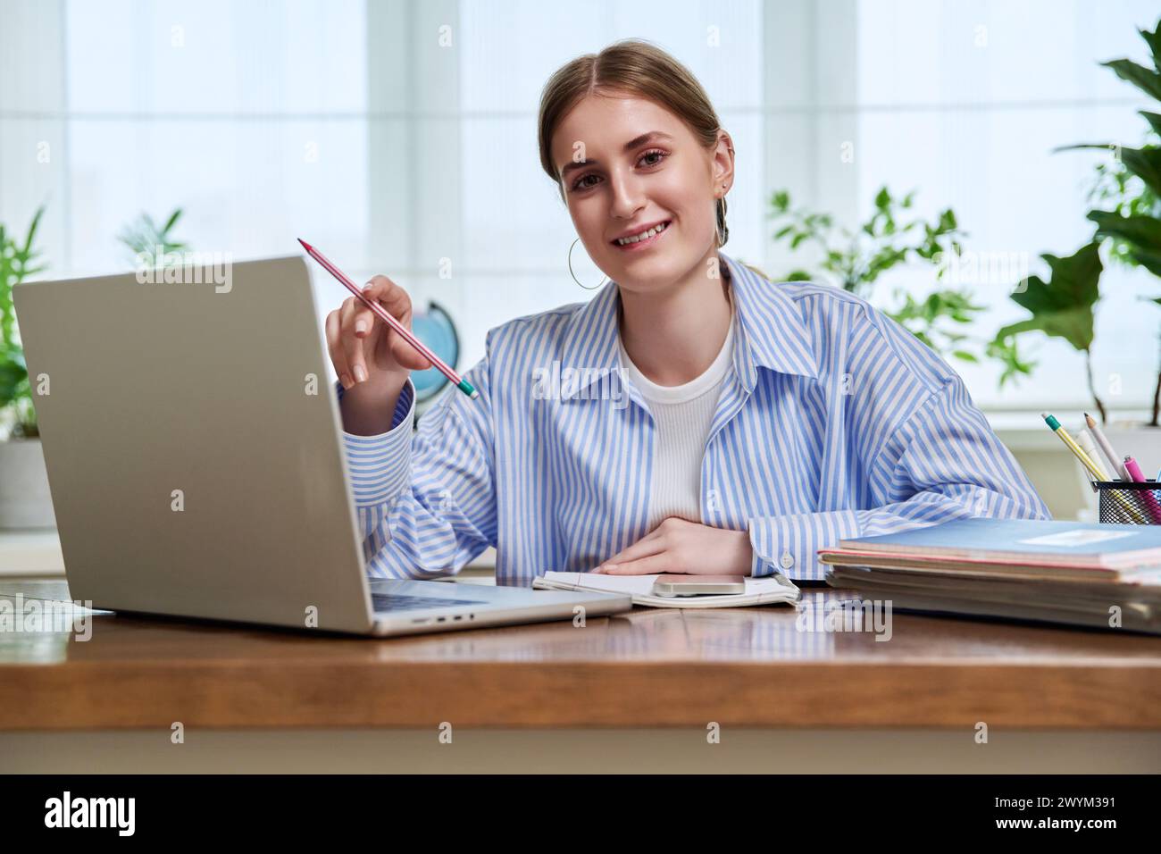 High school, college student smiling young female sitting at desk with ...