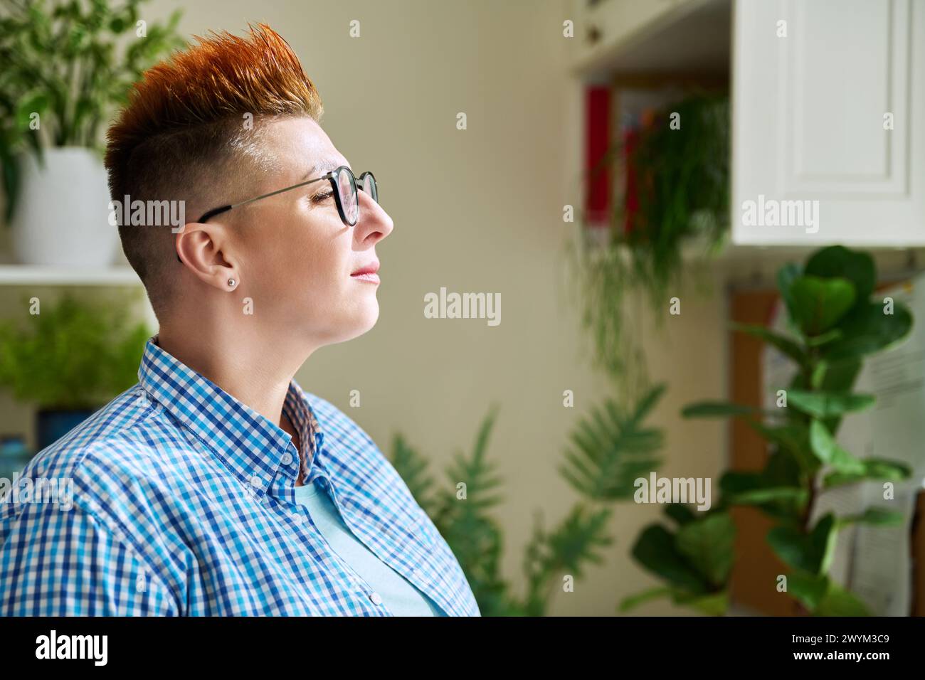Profile portrait of serious middle-aged woman in glasses looking at window Stock Photo - Alamy