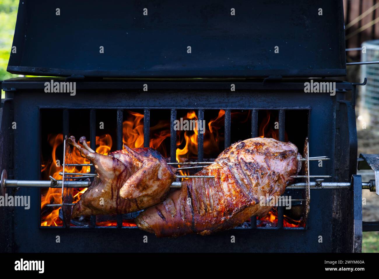 Roasting pork and turkey on spit Stock Photo - Alamy